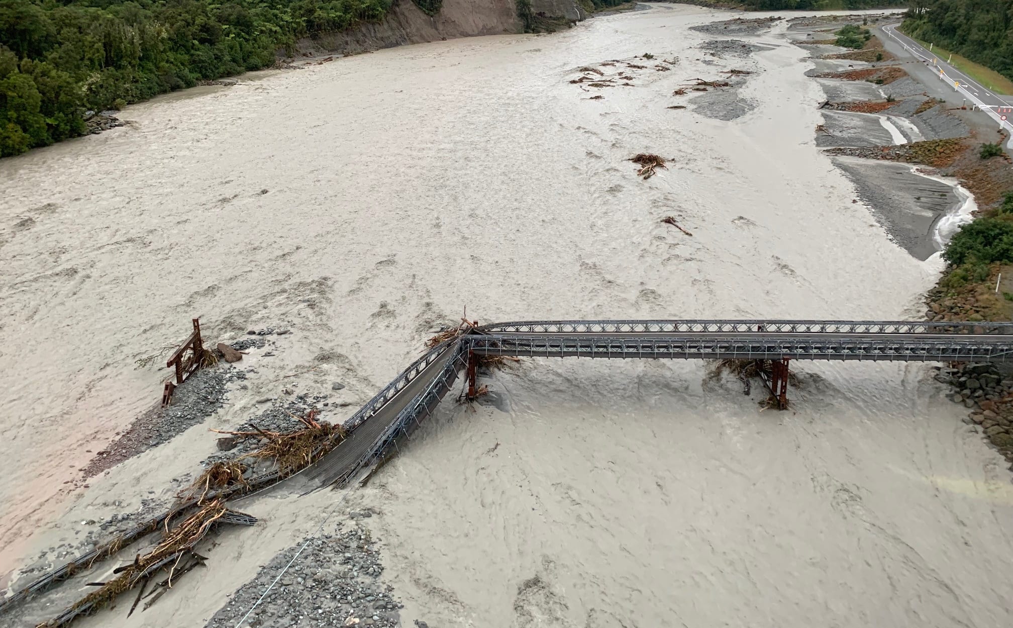 'Lifeline' bridge washed away in West Coast flooding | RNZ News