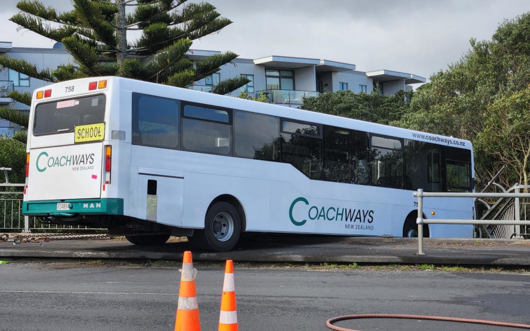 Bus crashes into barrier in Auckland, dangles off bridge | RNZ News